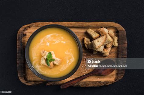 검은 배경에 나무 판이있는 어두운 접시에 빵 부스러기와 크림과 시금치호박과 당근 수프 가을에 대한 스톡 사진 및 기타 이미지