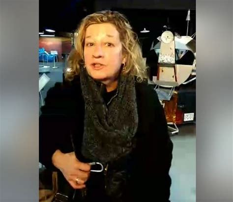 A Woman In Black Jacket And Scarf Posing For Camera