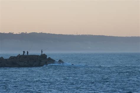 Pescadores Nos Oceanos Groupe De Homens Ficam Na Costa Do Mar Com Vara