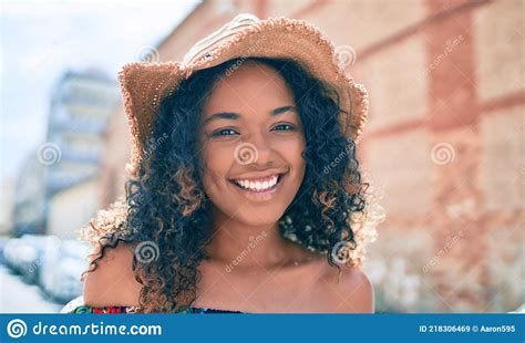 Young African American Woman With Curly Hair Smiling Happy Outdoors