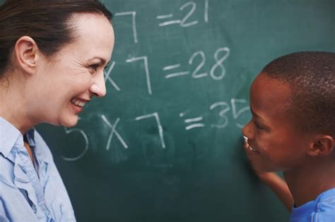 Premium Photo Math Teacher And Boy Learning At Chalkboard In Classroom For Solving Number
