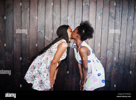 Two Black African Girlfriends At Summer Dresses Posed Against Dark
