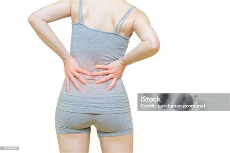 회색 옷을 입은 여성의 낮은 몸은 통증의 자리에서 뒤쪽 부위에 손을 얹고 빨간색 허리 통증 흰색 배경에 건강 관리 개념을