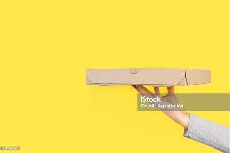 노란색 배경에 갈색 골판지 피자 상자를 들고 있는 여자 손 노란색 배경에 대한 스톡 사진 및 기타 이미지 노란색 배경 피자 닫은 Istock