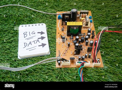 An Electronic Circuit Board And Wires With A Notepad Reading Big Data On Grass A Data Park