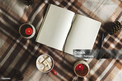 가 겨울의 코코아 커피 또는 따뜻한 격자 무늬에 마 시 멜로와 핫 초콜릿 머그잔 노트북 펜 갈 랜드 콘 배경 따뜻한 아늑한 가정