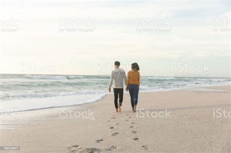 해변에서 모래에 발자국을 남기면서 걷는 인종 커플의 전체 길이 후방 보기 커플에 대한 스톡 사진 및 기타 이미지 커플 떠남