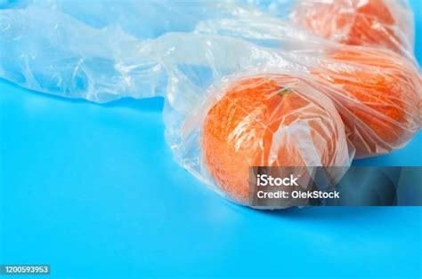 파란 배경에 폴리에틸렌 백에 담긴 신선한 통 만다린 또는 오렌지 과일 구매 개념입니다 텍스트를 위한 공간 가득 찬에 대한 스톡