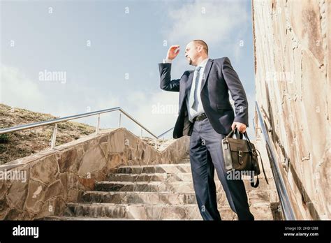 Confident Middle Age Businessman With Briefcase Walking Upstairs Close