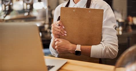 실내의 나무 책상 근처에서 클립보드를 손에 들고 있는 여성의 자른 머리 초상화 사진 Unsplash의 구매 및 판매 이미지