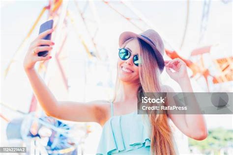 놀이 공원에서 일회용 모바일 귀여운 어린 소녀 미소 하 고 Selfie 그녀는 선글라스와 모자를 착용 라이프 스타일의 가까운에 대한 스톡 사진 및 기타 이미지 Istock