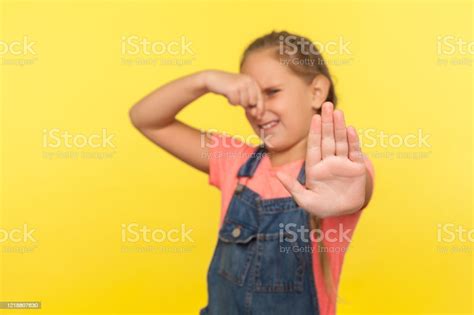 끔찍한 냄새 데님 바지에 머리를 묶은 어린 소녀는 숨을 들고 그녀의 코를 꼬집고 정지 제스처를 보여주는 가리기에 대한 스톡 사진