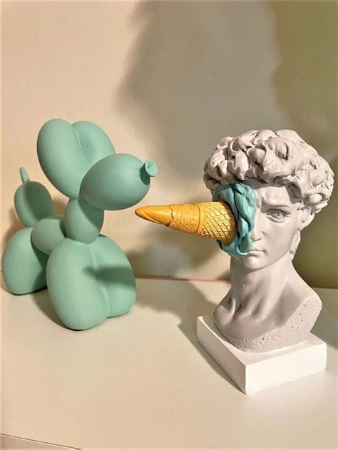 A Statue Of A Woman With An Ice Cream Cone On Her Head Next To A