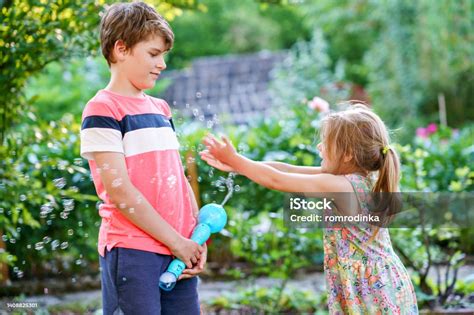 행복한 작은 유치원 소녀와 학교 아이 소년 비누 거품 송풍기와 재미를 아이들 사랑스러운 형제가 함께 놀고 있습니다 활동적인 재미