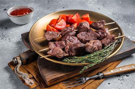 Premium Photo Lamb Shish Kebab Grilled Skewers In A Plate With Tomato Gray Background Top View