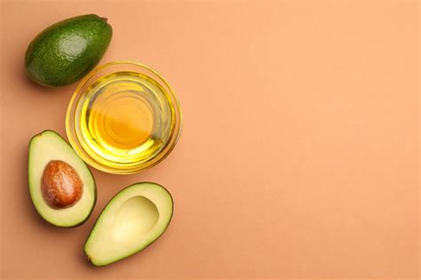 그릇에 식용유와 베이지색 배경에 신선한 아보카도 평평하게 놓여 있습니다 텍스트를 위한 공간 0명에 대한 스톡 사진 및 기타