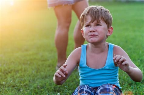 Premium Photo Boy Crying While Sitting On Grassy Field During Sunset