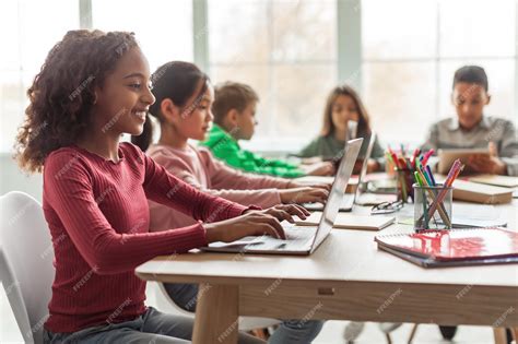 Premium Photo Black Schoolgirl Using Laptop Sitting With Multiethnic