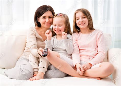 Mom Hugging Daughters While Watching Tv At Home 이미지 1297425728 게티이미지뱅크