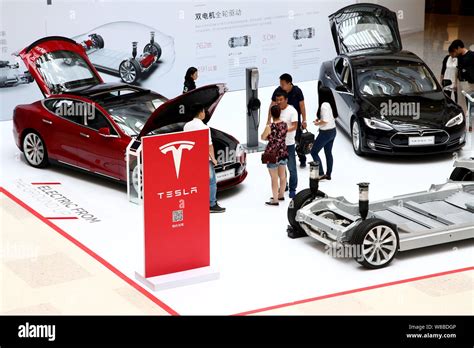 FILE Chinese Shoppers Look At Tesla Model S Electric Cars On Display During A Promotional