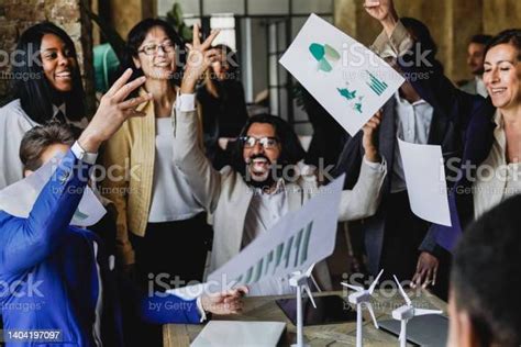 신재생 에너지 프로젝트 성공을 축하하는 다민족 사업가들이 함께 사무실에서 문서를 던지다 풍차에 집중 동아시아 문화에 대한 스톡