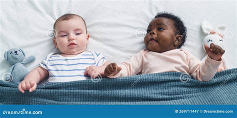 Two Adorable Babies Smiling Confident Lying On Bed At Bedroom Stock