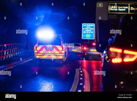 Police Car With Blue Flashing Lights At Night Responding To An