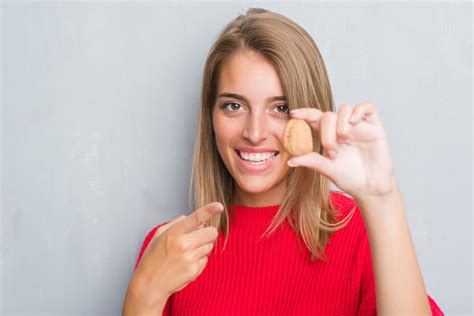 호두를 손과 손가락으로 가리키는 매우 행복 들고 그런 지 회색 벽을 통해 서 아름 다운 젊은 여자 가리키기에 대한 스톡 사진 및 기타 이미지 Istock