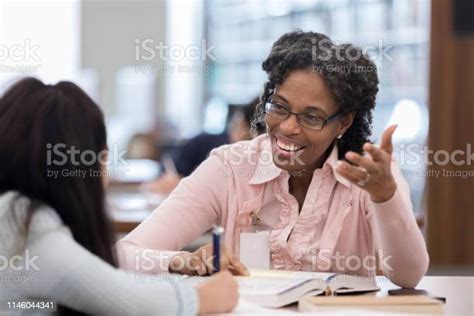 교사는 도서관에서 숙제를 가진 미확인 학생을 도와줍니다 교사 교육 관련 직업에 대한 스톡 사진 및 기타 이미지 교사 교육
