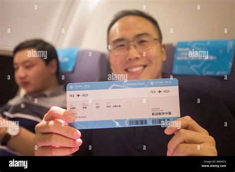 A Chinese Passenger Shows His Boarding Pass Onboard Flight Cz6163 From