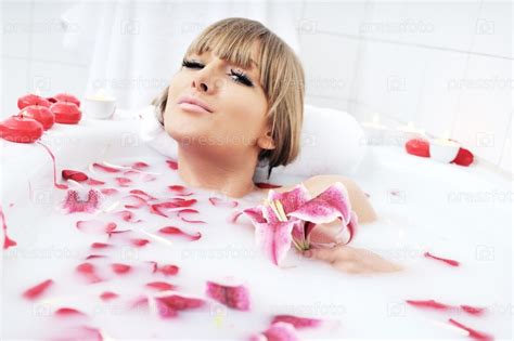 Женщина принимает ванну с молоком и лепестками спа процедура Stock Image Everypixel