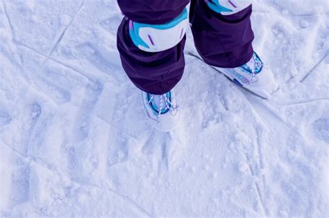 Menina roupas de inverno proteções patinando na pista de gelo aprendendo a treinar a