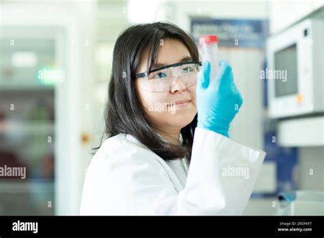 Young Chinese Scientist Female Controlling A Sample In A Tube Stock