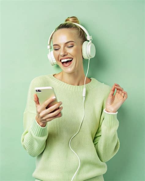 Happy Smiling Woman Listening To Music On Headphones And Holding A