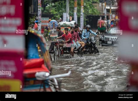 A Rickshaw Carries Several Passengers Through The Waterlogged Streets