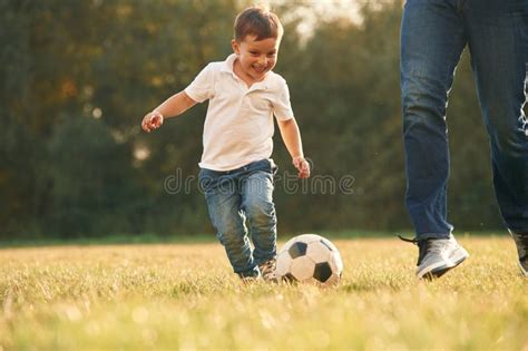 View Of The Field With Soccer Ball Father And Little Son Are Playing
