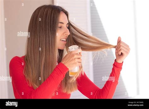 Front View Of Young Happy Woman Applying Split Ends Treatment On Her