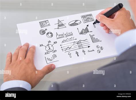 Cropped Image Of Businessman Preparing Analytical Diagrams At Table In