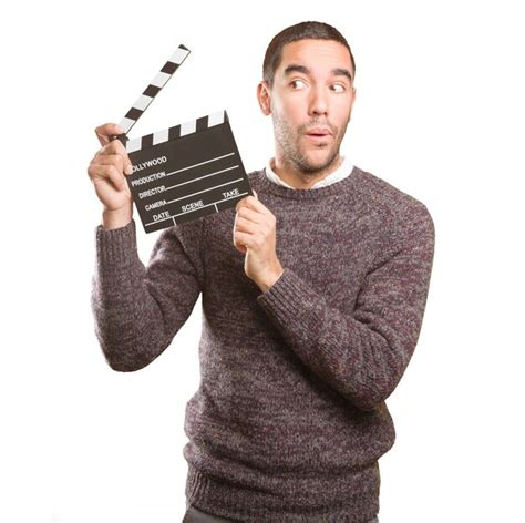 Смешной молодой человек используя Clapperboard Премиум Фото