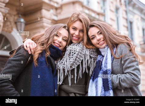 Portrait Of A Three Smiling Girlfriends Standing Together Outdoors With