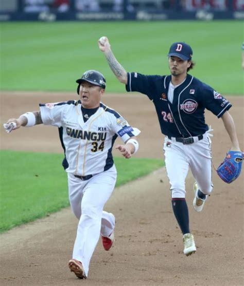Two Baseball Players Running On The Field During A Game One Has His