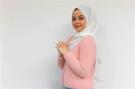 ピンクのブレザーを着た美しい笑顔のアジアの若いヒジャーブ女性は手をこすりながらカメラを見て自信を持って見える白い背景に分離型 1人の