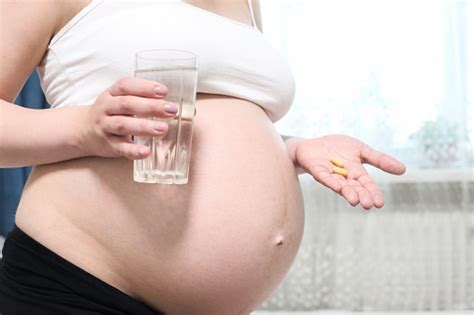 손에 알약과 물을 임신 한 배의 클로즈업 아기를 기다리고 임신 아이의 기대 미래의 파렌스 산전 비타민 개념에 대한 스톡 사진 및 기타 이미지 Istock