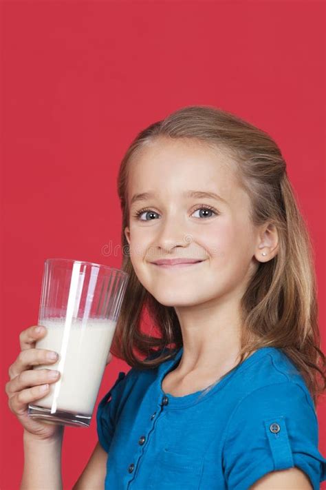 Chica Joven Que Sostiene El Vidrio De Leche Mientras Que Mira Para