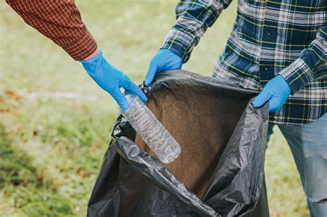 쓰레기를 모으는 남자 검은 가방에 플라스틱 병을 모으는 자원 봉사 공원을 청소하고 오염을 피하고 환경 친화적입니다 20 24세에 대한 스톡 사진 및 기타 이미지 Istock