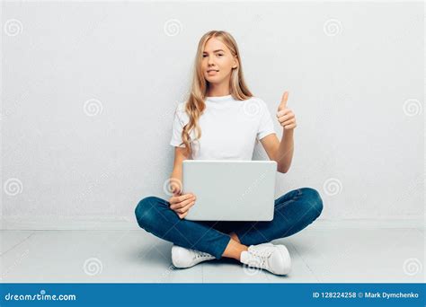 Beautiful Girl In White T Shirt Sitting On The Floor With Laptop And