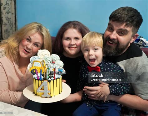 가족은 네 살 짜리 아들의 생일을 축하합니다 케이크와 숫자 4가족 아들의 생일 아빠와 엄마와 아이들과 케이크 가정 주방에 대한