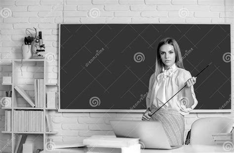 Young Blonde Teacher Pointing On Lesson Cute Young Woman With Pointer Teaching Near Blackboard