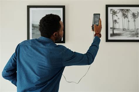 Premium Photo Man Scanning Qr Code On Photograph In Art Gallery To Listen To Auidioguide