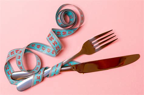 분홍색 배경에 말린 측정 테이프 포크 및 칼의 구성과 디자인에 대한 빈 공간 과체중 개념 0명에 대한 스톡 사진 및 기타 이미지 Istock